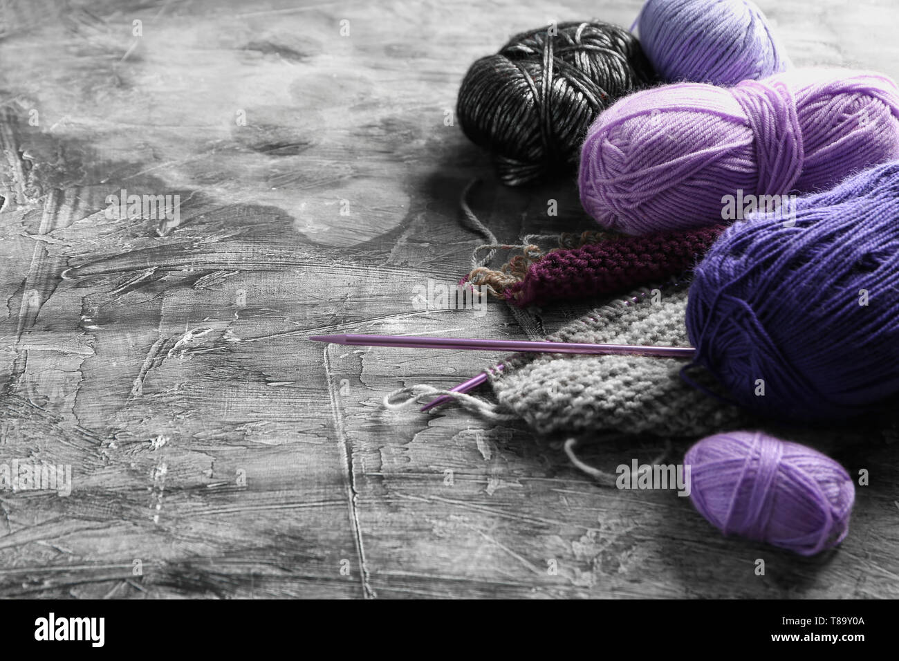 Colorful knitting yarn with unfinished clothes on table Stock Photo - Alamy