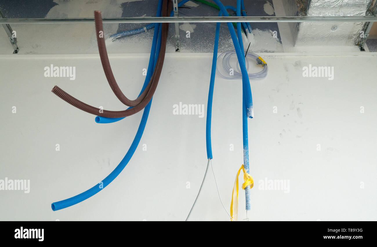 A detail view of colorful electrical cables hanging from the ceiling in ...