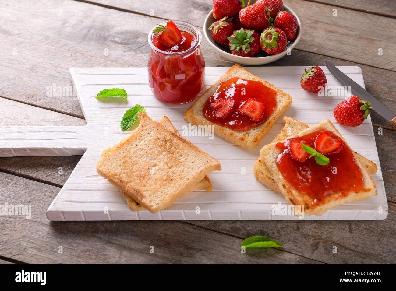 Composition with tasty strawberry jam on wooden table Stock Photo - Alamy