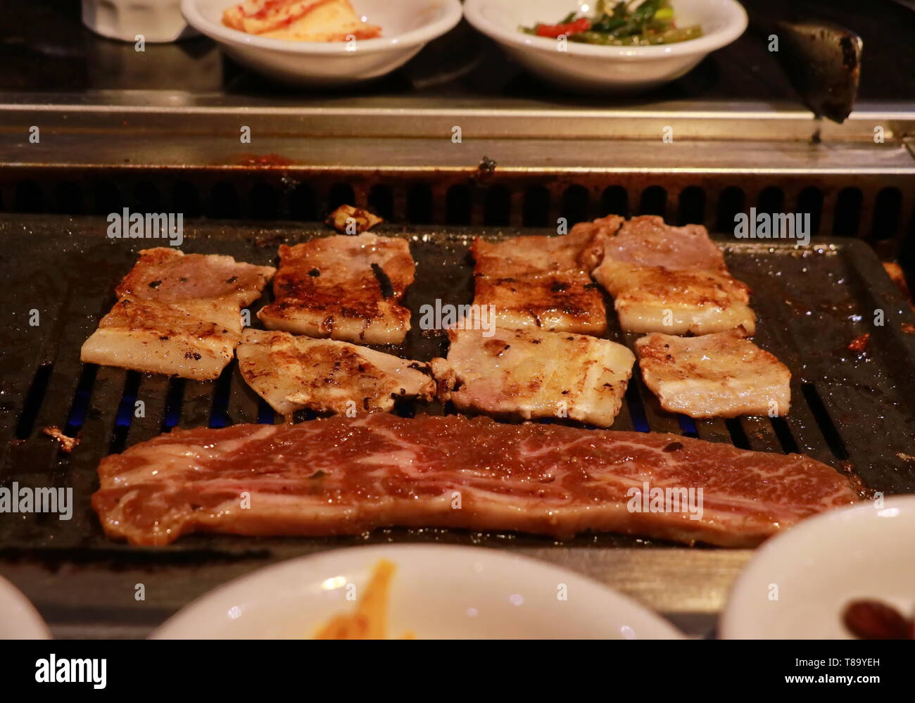 Pork belly and beef short ribs on the grill (KBBQ Stock Photo - Alamy