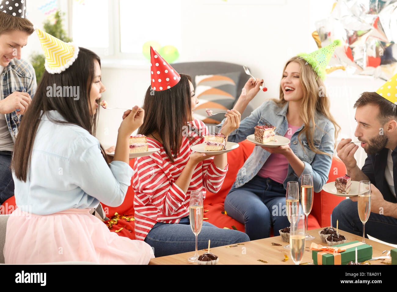 Young people eating tasty cake at birthday party indoors Stock Photo ...