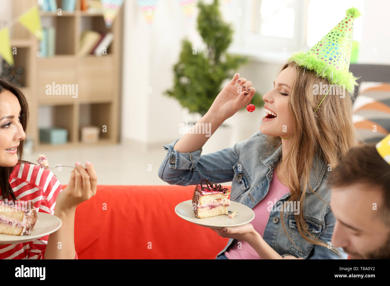 Young people eating tasty cake at birthday party indoors Stock Photo ...