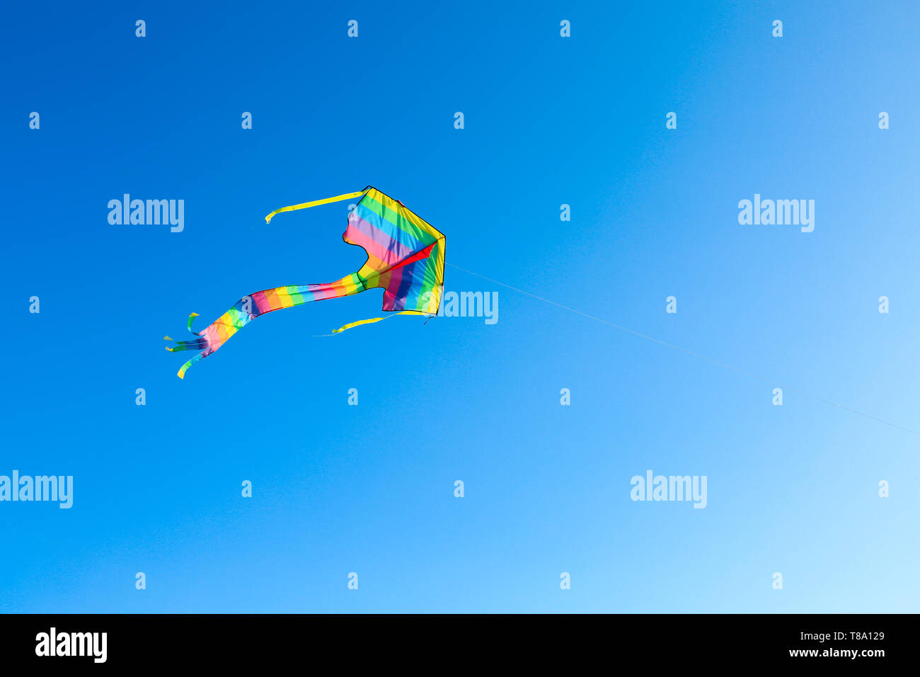 Beautiful kite flying in blue sky Stock Photo - Alamy