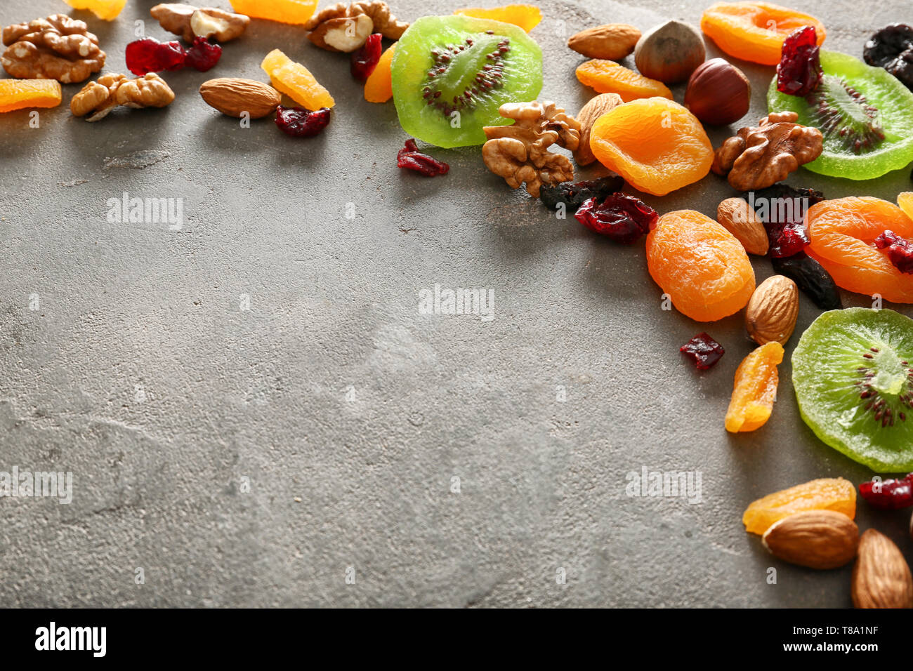 Various nuts and dried fruits on grey textured background Stock Photo ...
