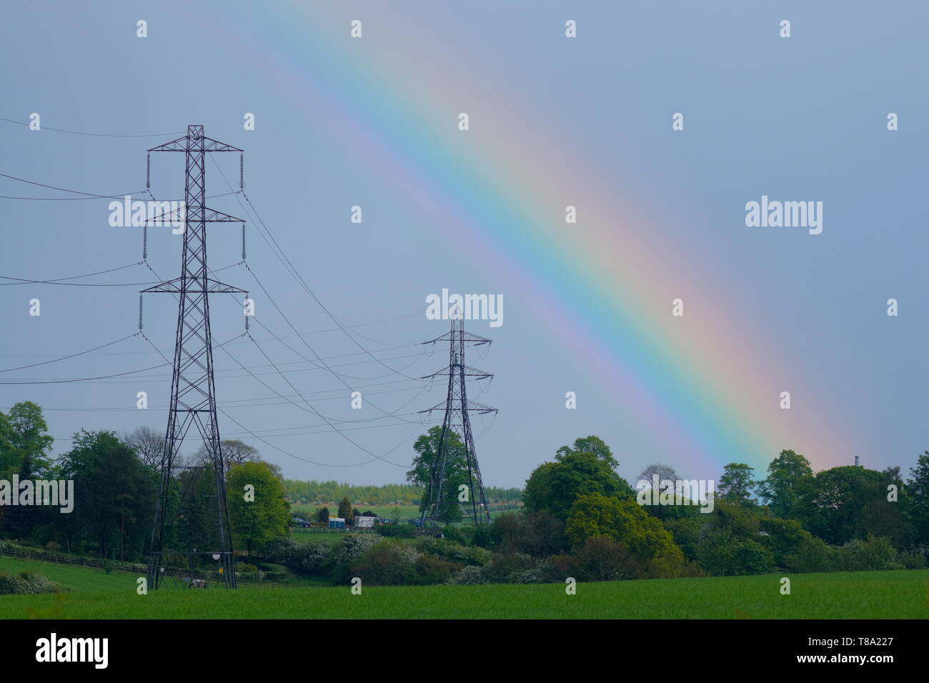 Pylons running through rural landscape with a rainbow Stock Photo - Alamy