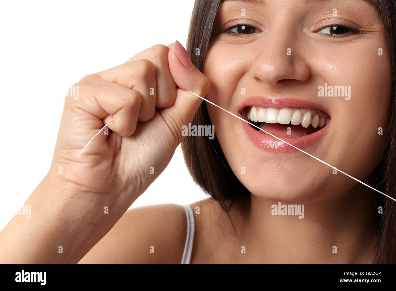 Young woman flossing her teeth on white background Stock Photo - Alamy