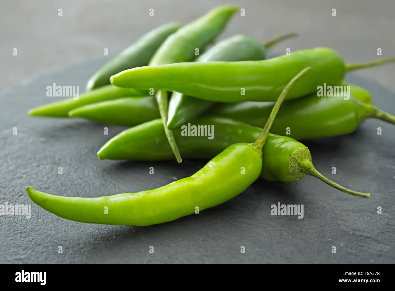 Fresh chili peppers on grey textured background Stock Photo - Alamy
