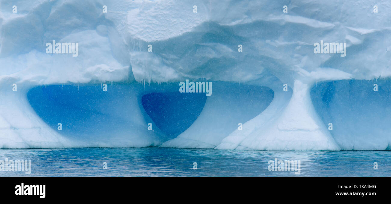 Sculptural iceberg shrouded in fog and floating in the waters of ...