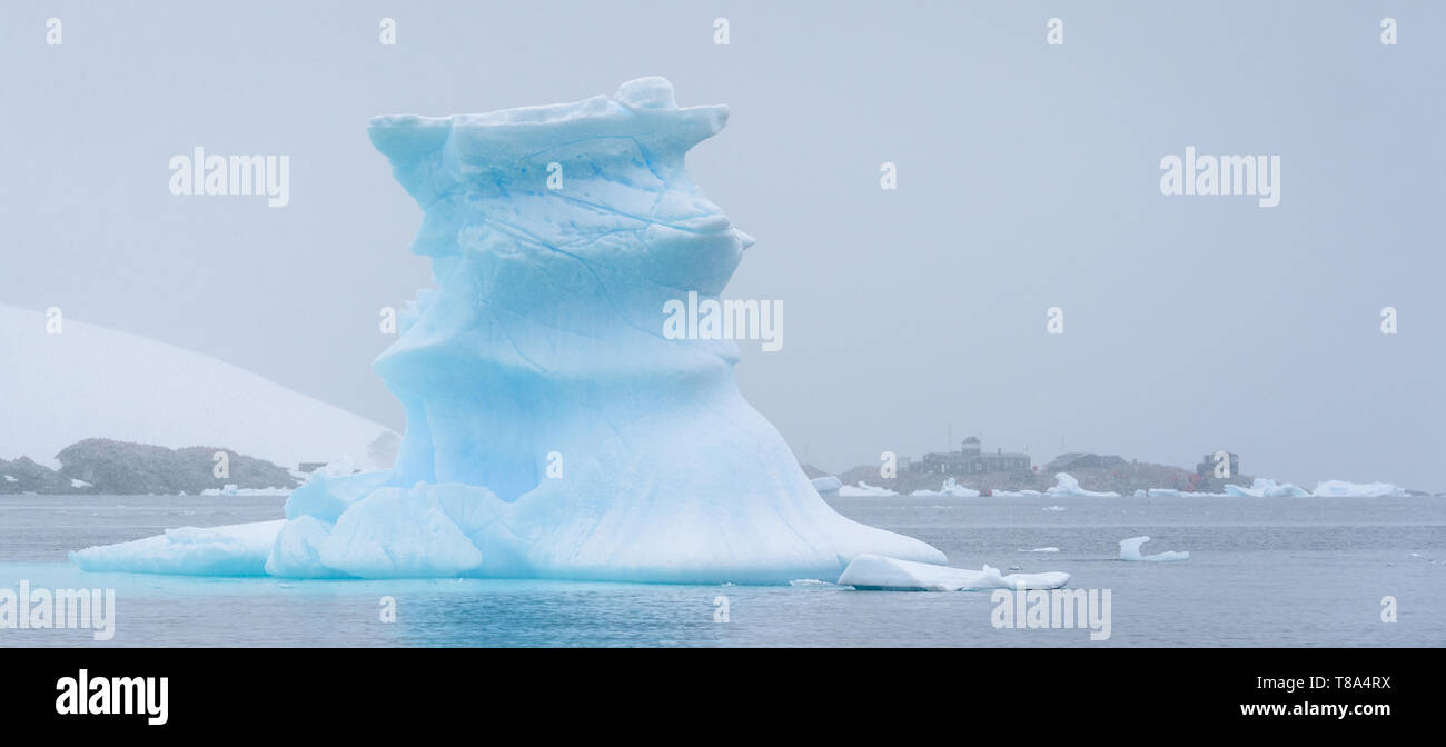 Beautiful turquoise blue iceberg floating in the Antarctic, against a ...