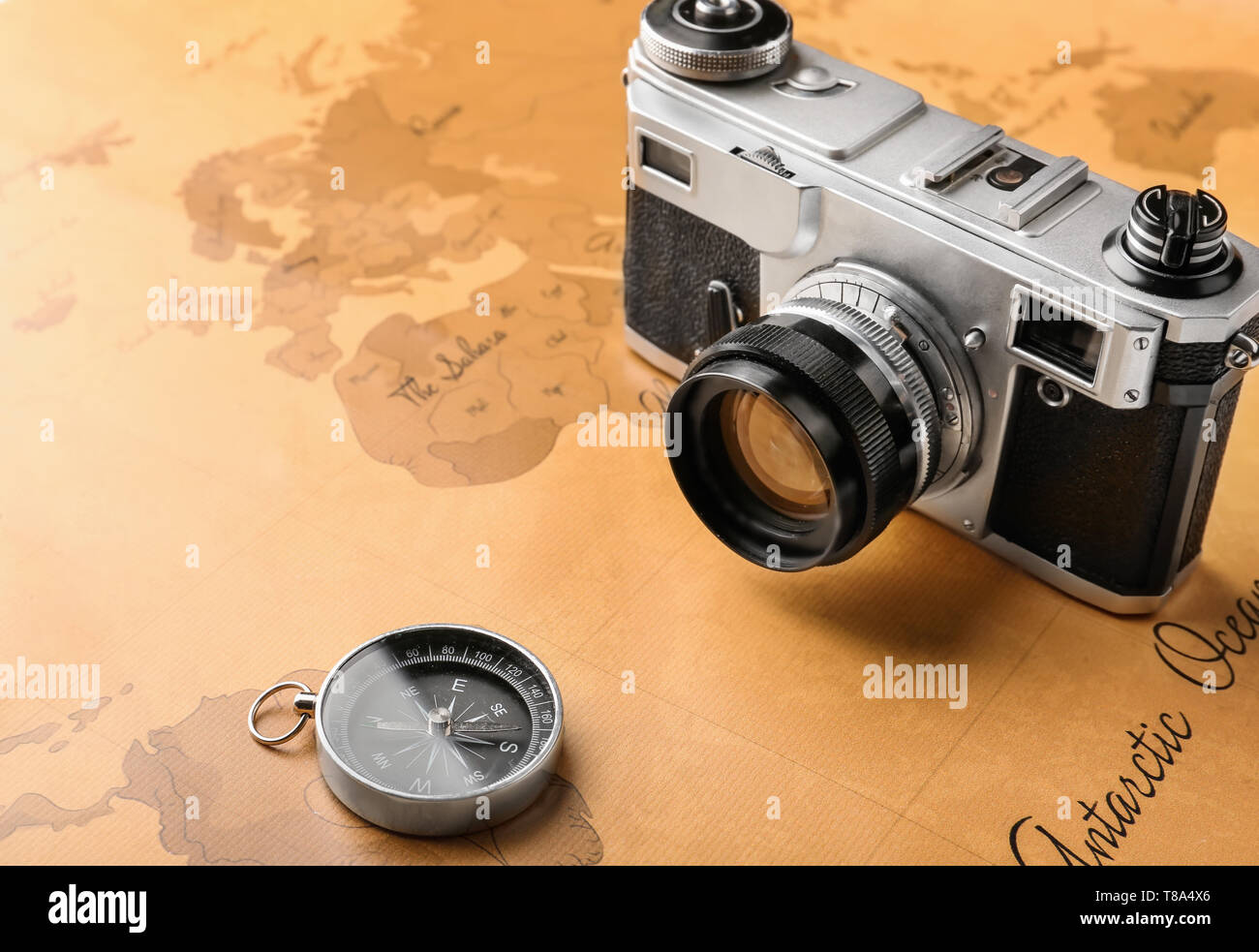 Photo camera and compass on vintage world map. Travel planning concept ...