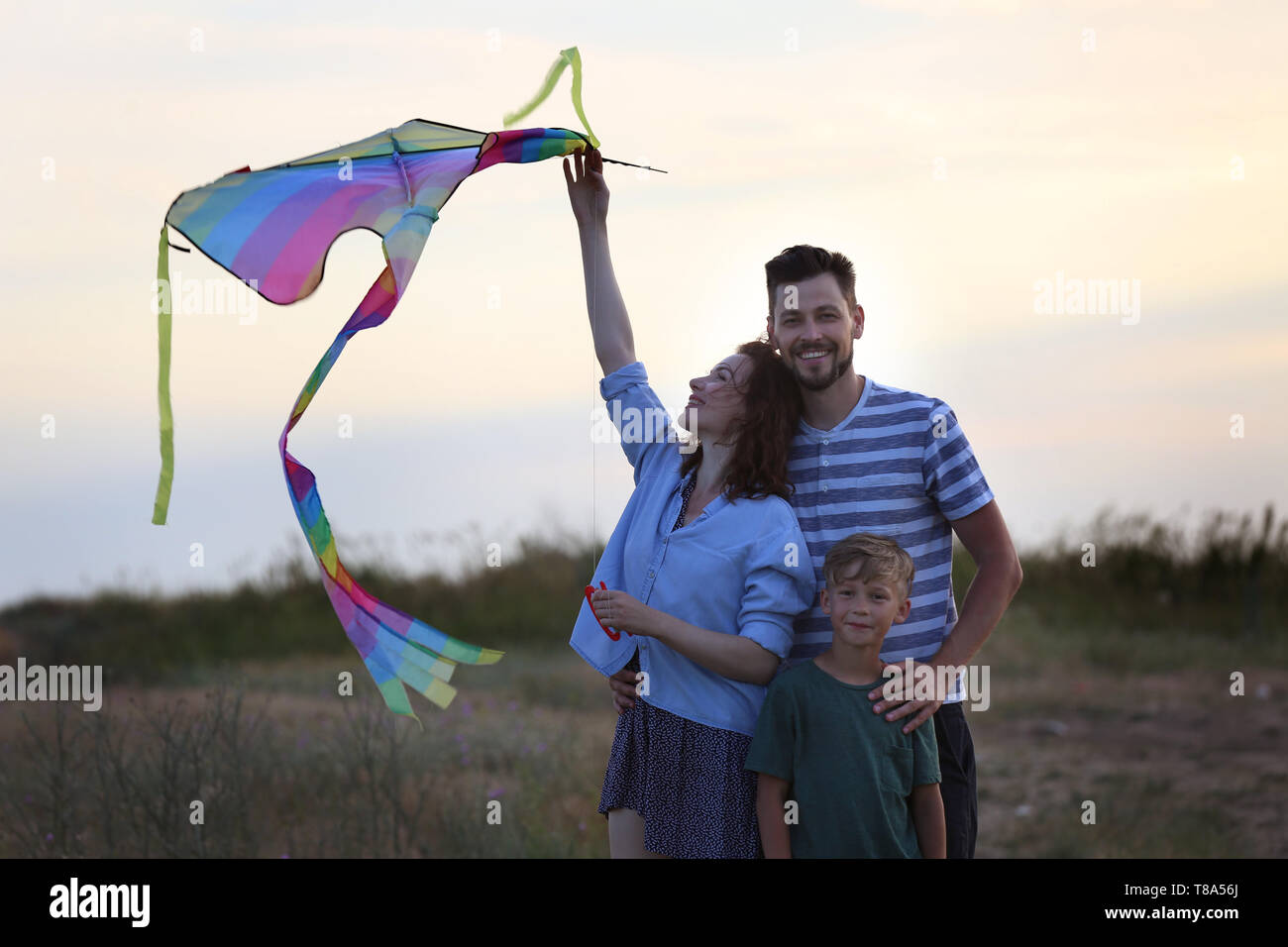 Happy family flying kite outdoors Stock Photo - Alamy