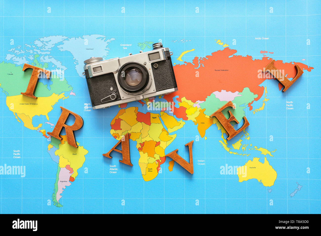 Word "Travel" and photo camera on world map Stock Photo - Alamy
