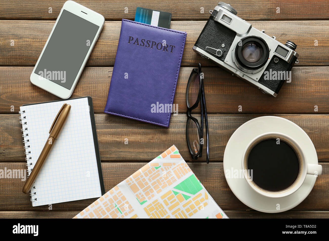 Composition with map, mobile phone, photo camera and passport on wooden ...
