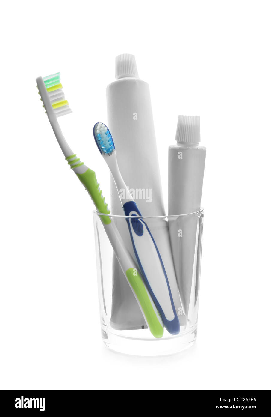 Cup with toothbrushes and paste on white background Stock Photo - Alamy