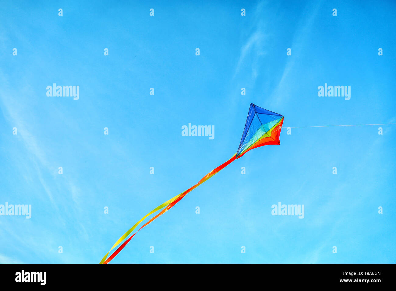 Colorful kite flying in blue sky Stock Photo - Alamy