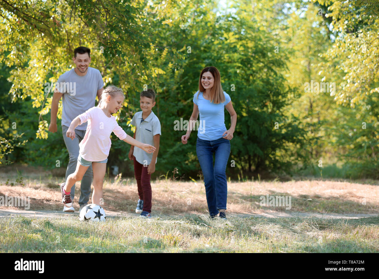 Happy family playing football outdoors Stock Photo - Alamy