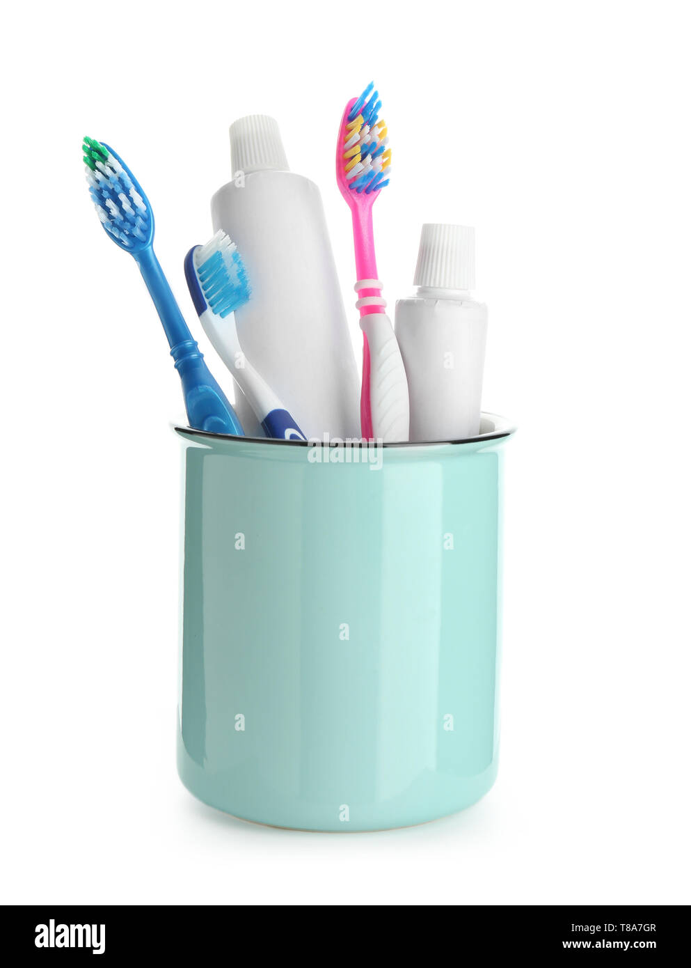 Cup with toothbrushes and paste on white background Stock Photo - Alamy