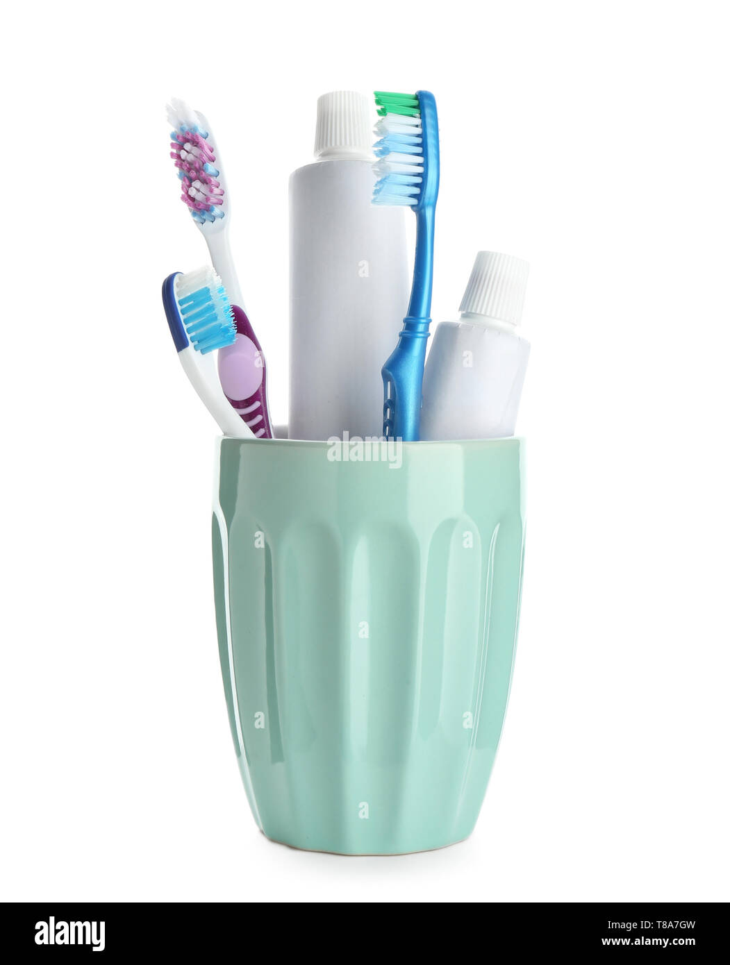 Cup with toothbrushes and paste on white background Stock Photo - Alamy