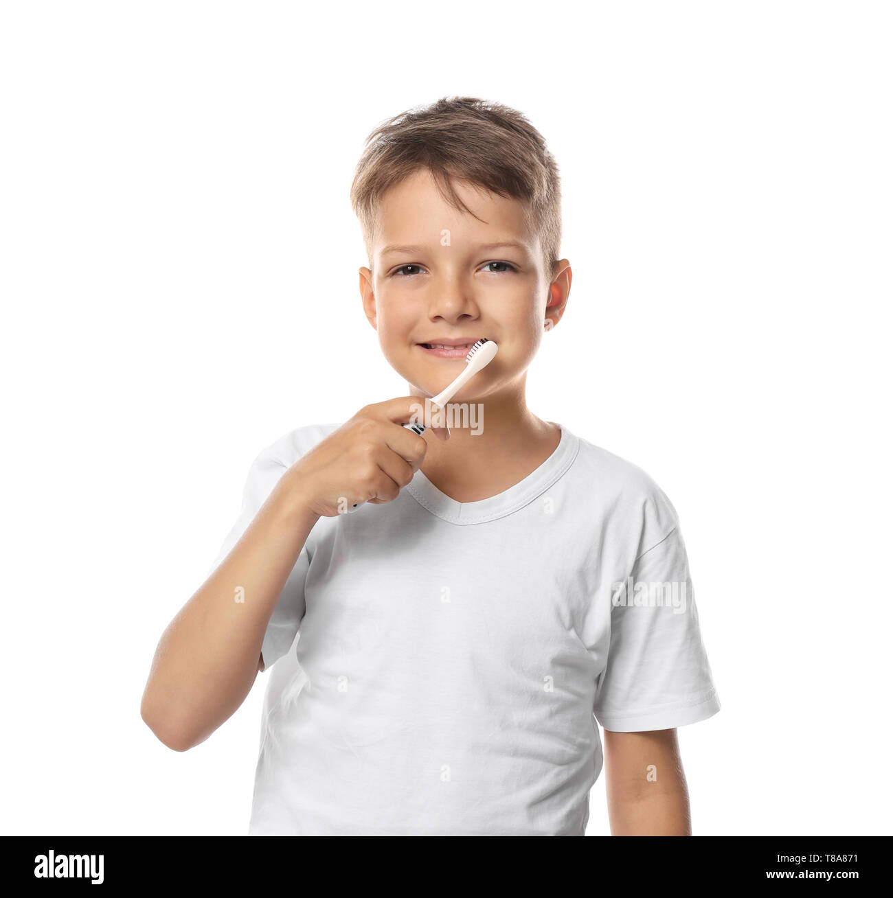 Cute little boy brushing teeth on white background Stock Photo - Alamy
