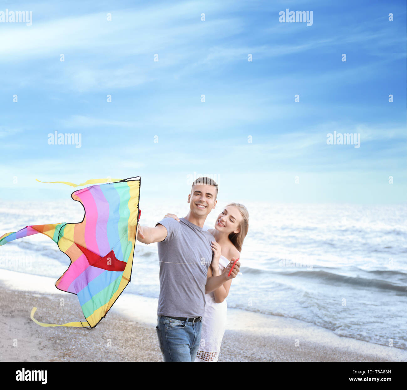Happy young couple flying kite hi-res stock photography and images - Alamy