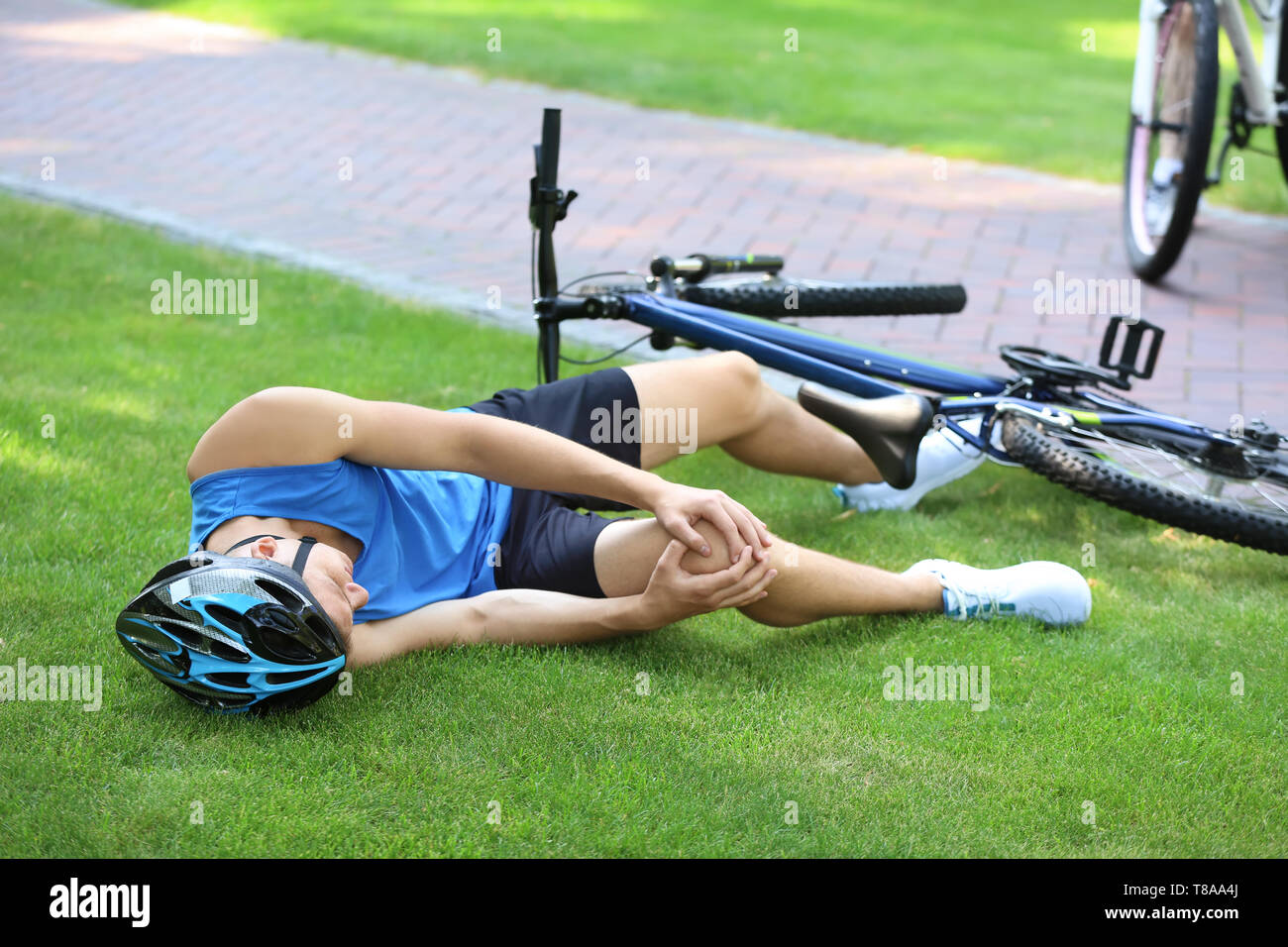 Young man fallen off his bicycle in park Stock Photo - Alamy