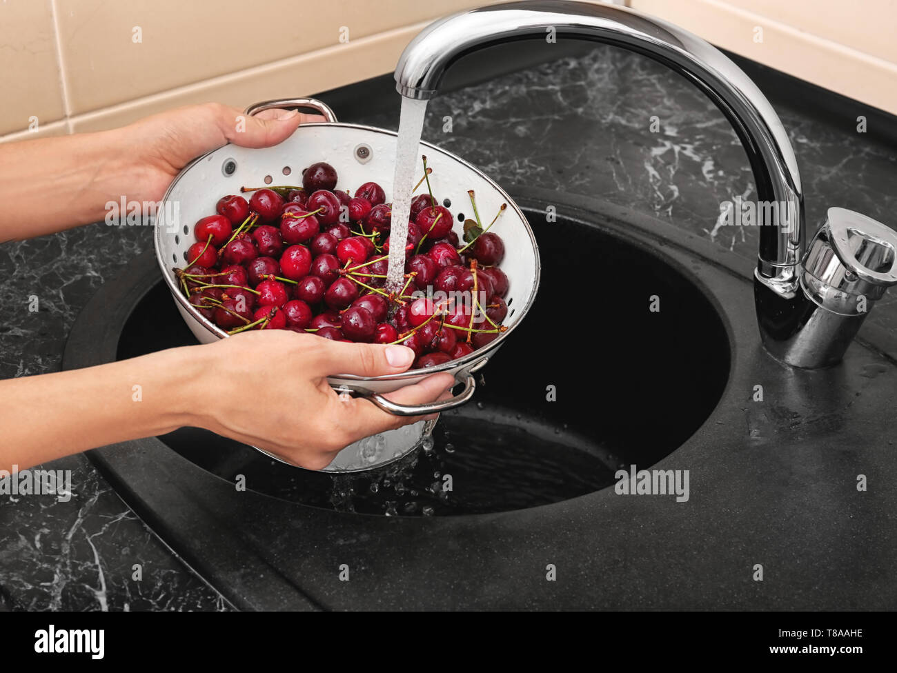 Woman washing fresh cherries in kitchen Stock Photo - Alamy