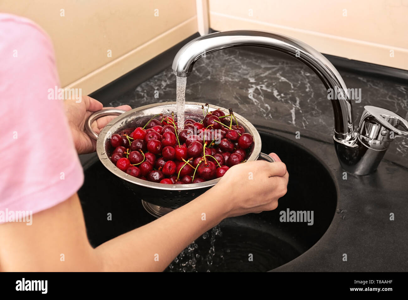 Woman washing fresh cherries in kitchen Stock Photo - Alamy