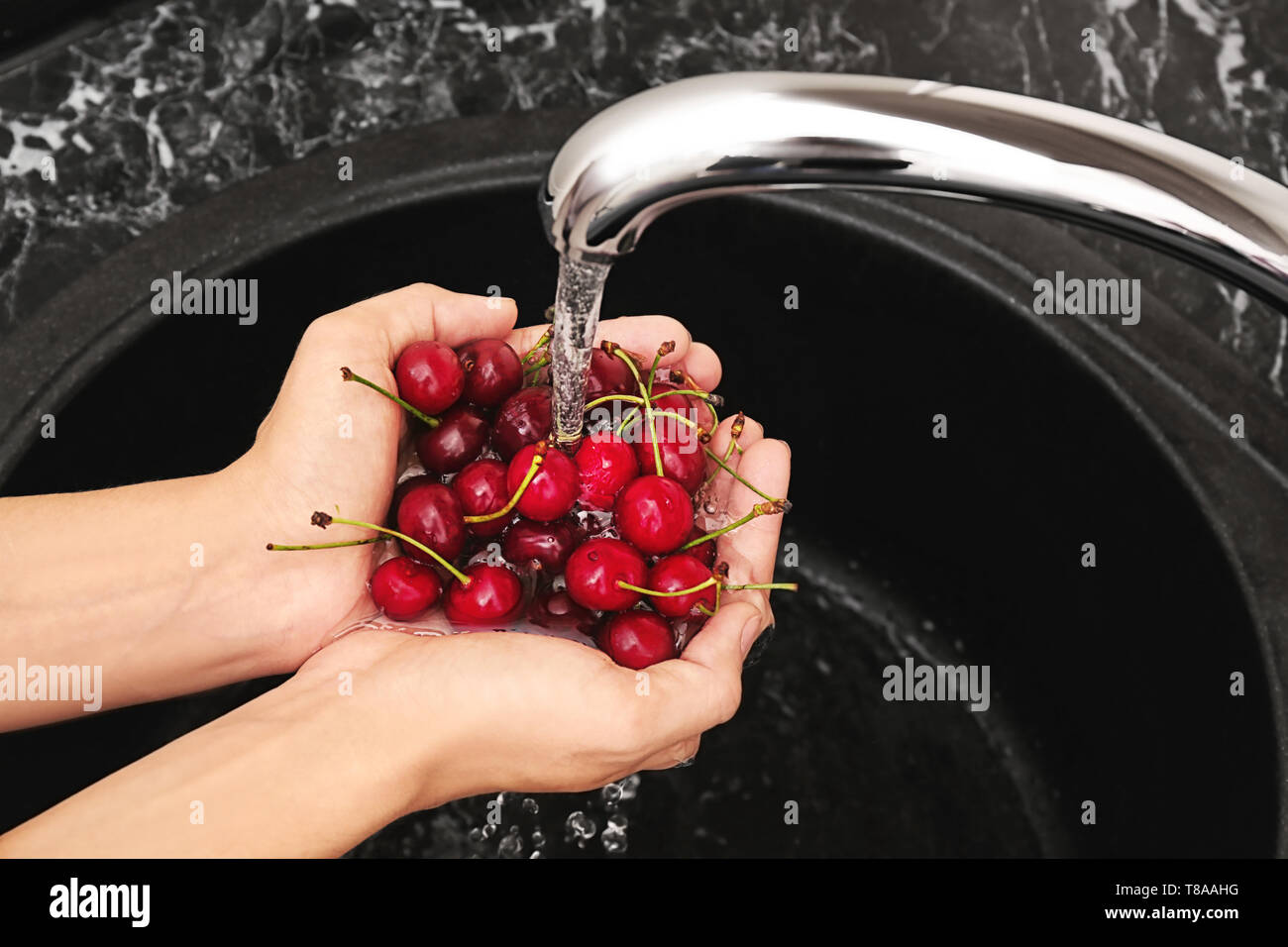 Woman washing fresh cherries in kitchen Stock Photo - Alamy