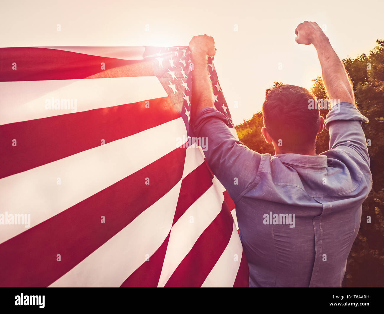 Handsome, young man waving an American flag Stock Photo - Alamy