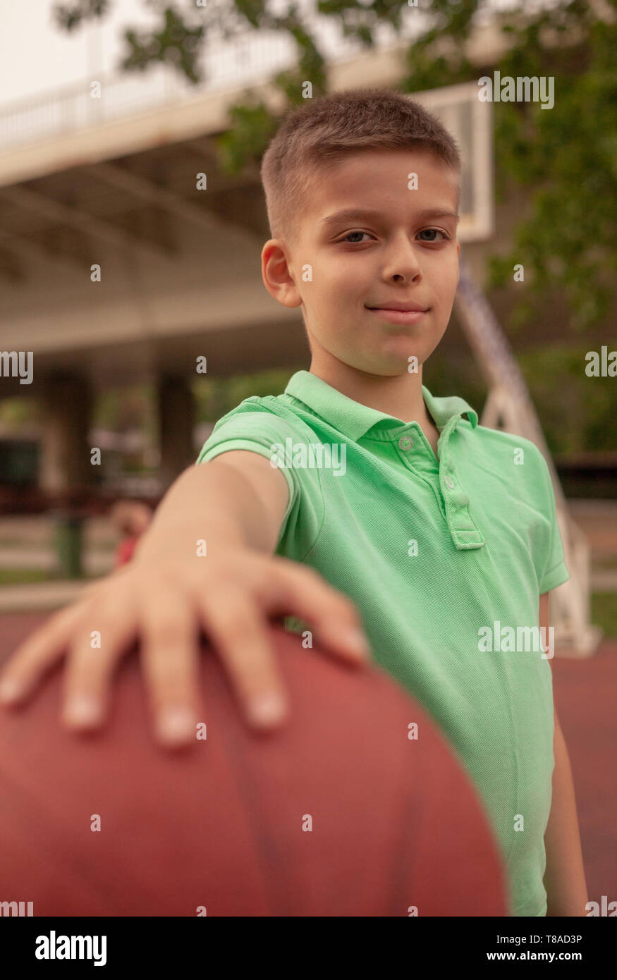 close-up of one nine years old boy, smirking to a camera, holding ...