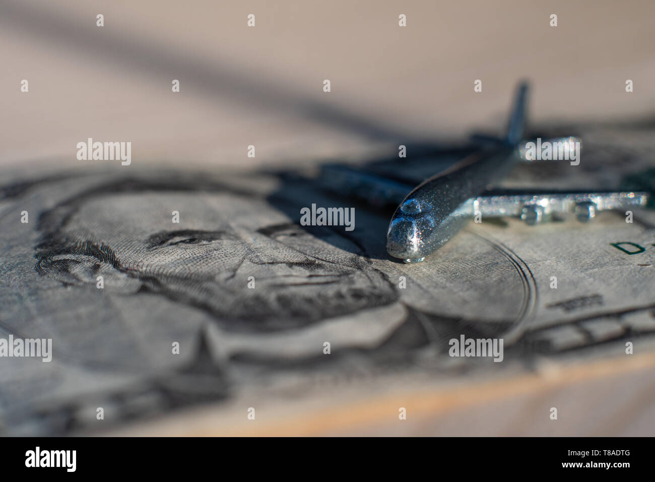 An airplane standing on five dollars. The concept of spending on ...