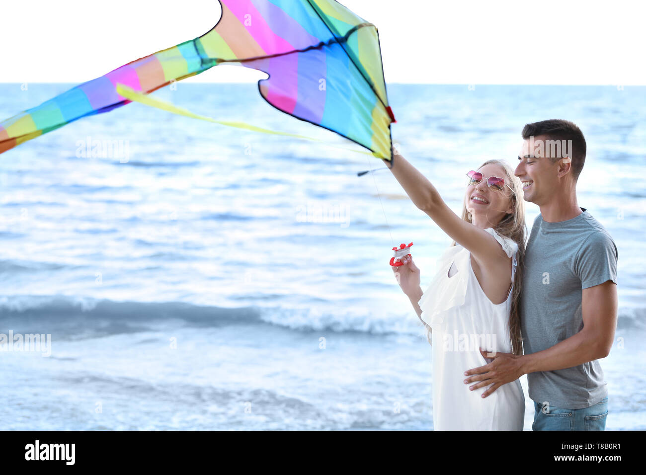 Happy young couple flying kite hi-res stock photography and images - Alamy