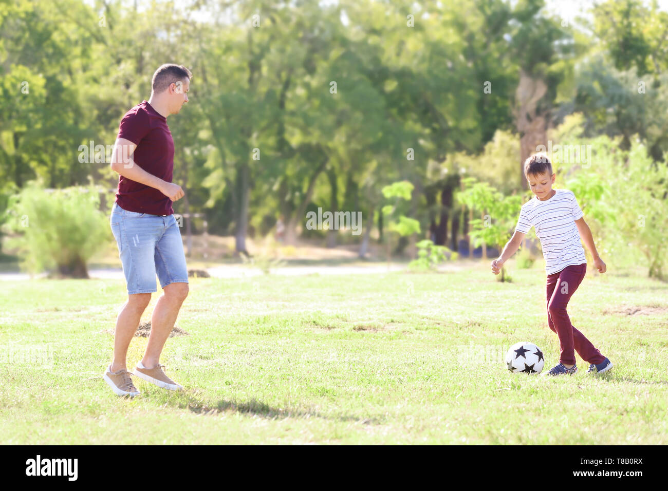 Little boy with his dad playing football outdoors Stock Photo - Alamy