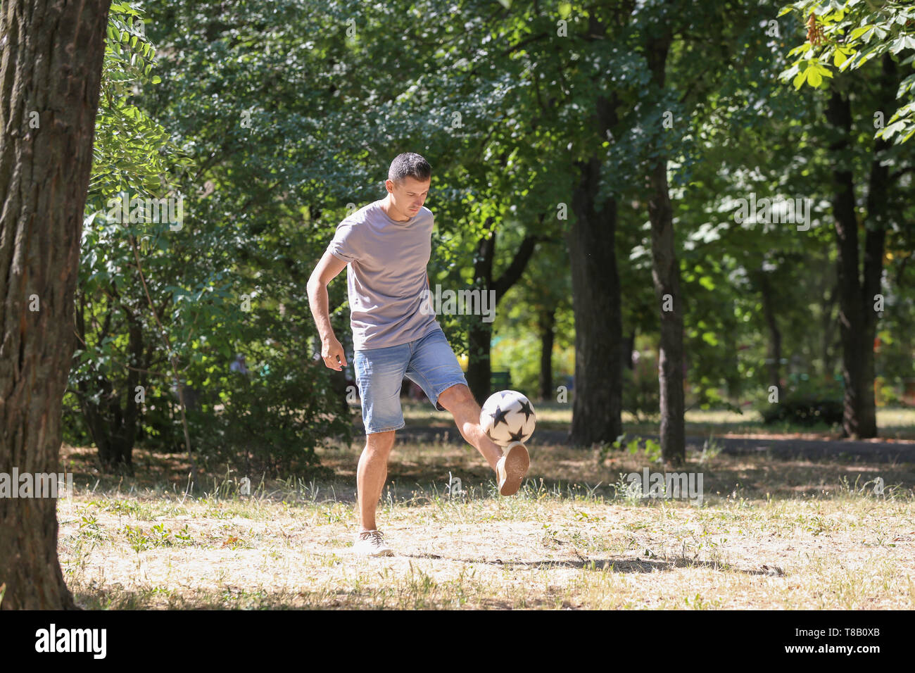 Handsome man playing football outdoors Stock Photo - Alamy