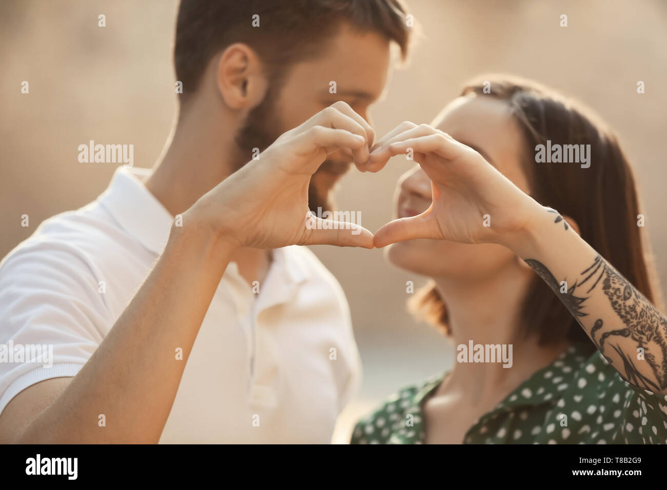 Happy lovely couple making heart with their hands outdoors Stock Photo ...