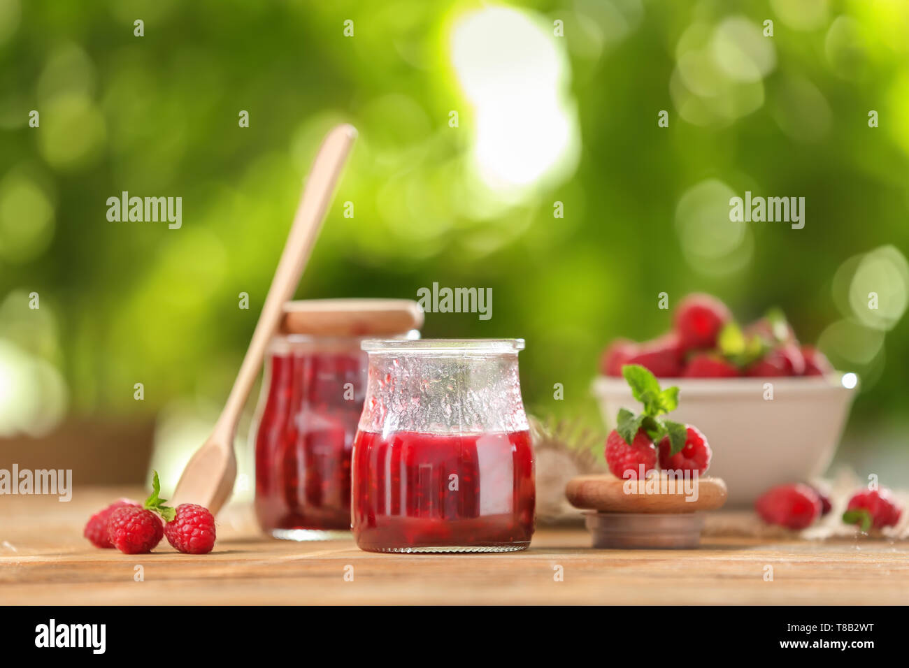 Composition with sweet raspberry jam on table outdoors Stock Photo - Alamy