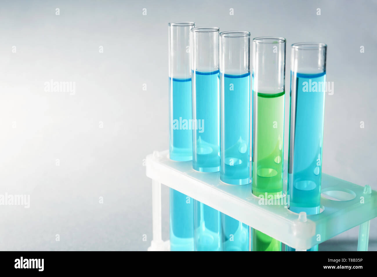 Test tubes with color liquids on light background Stock Photo - Alamy