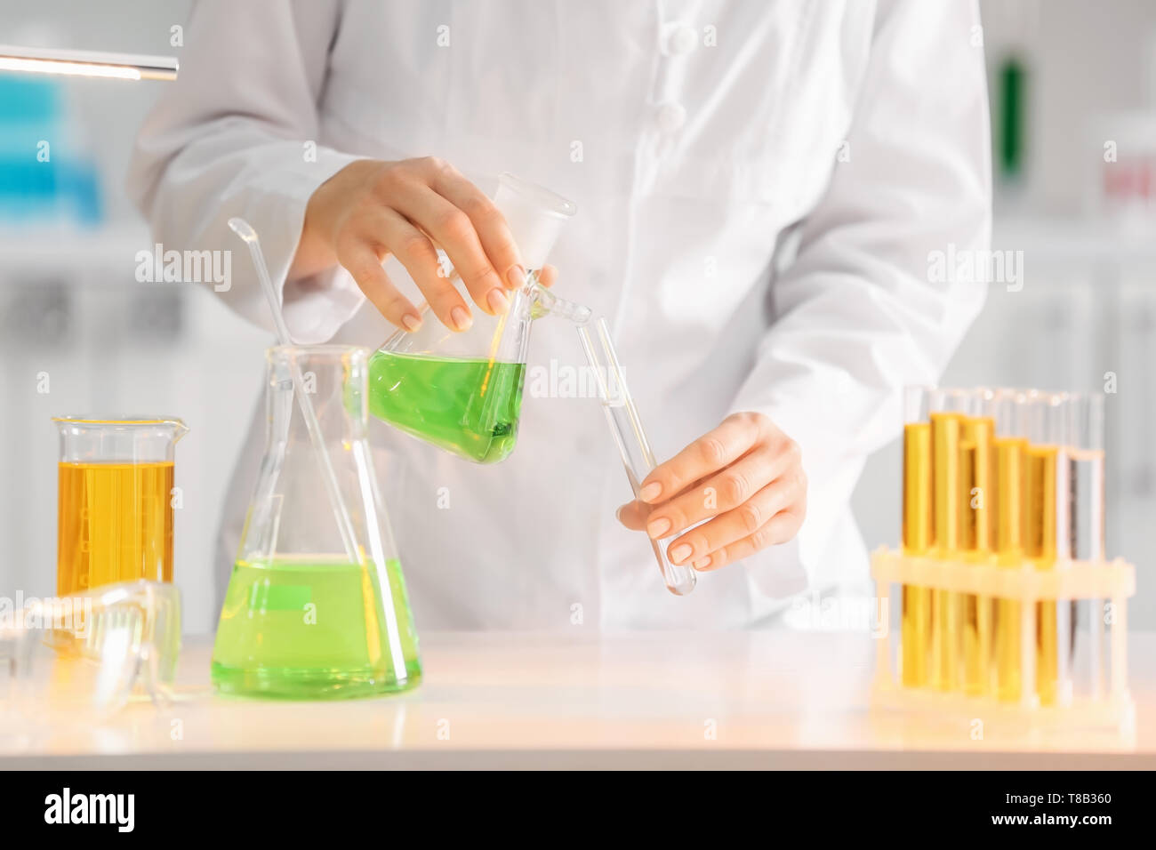 Scientist pouring color liquid into test tube in laboratory Stock Photo ...