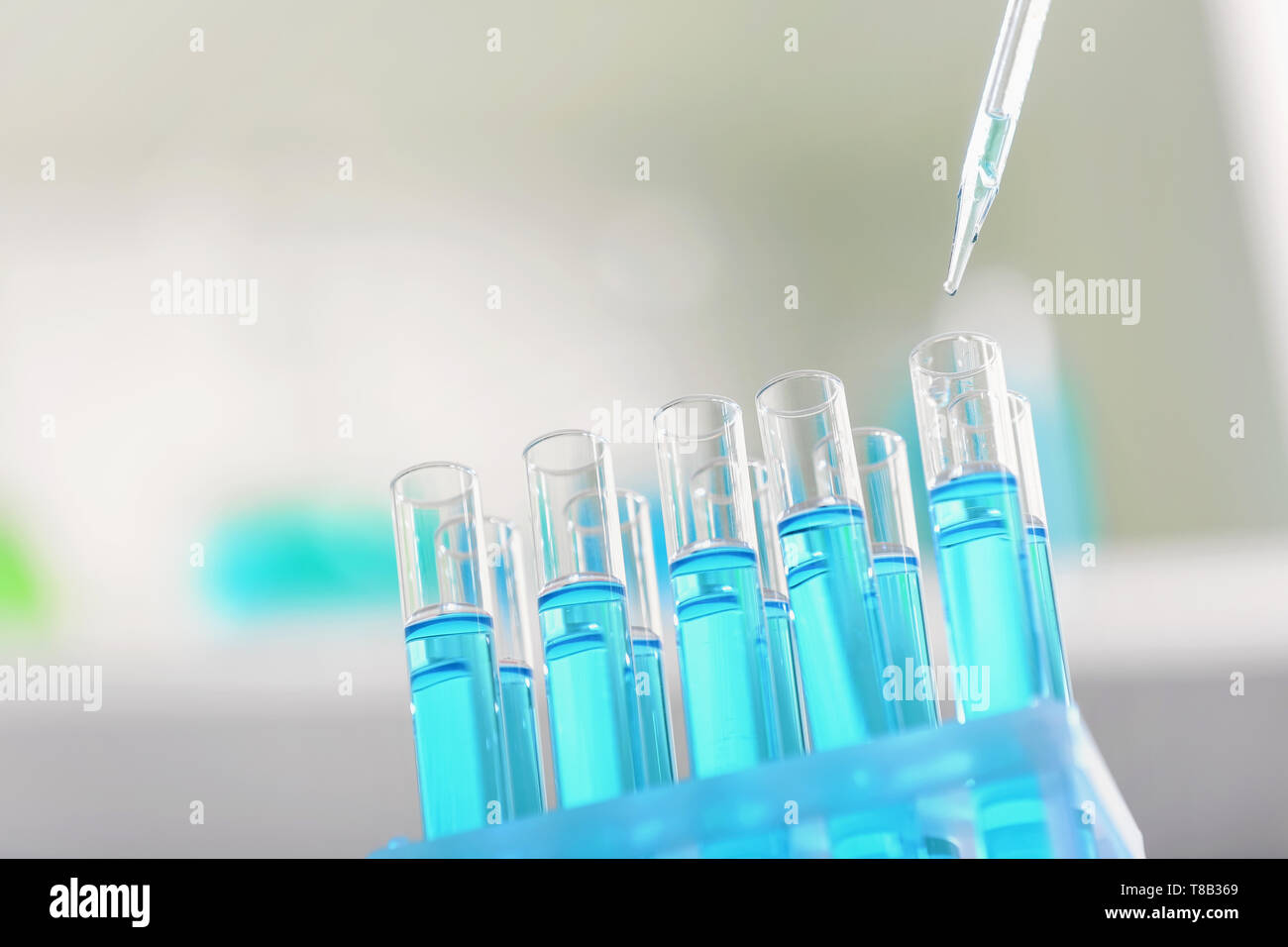 Dripping color liquid into test tubes in laboratory Stock Photo - Alamy