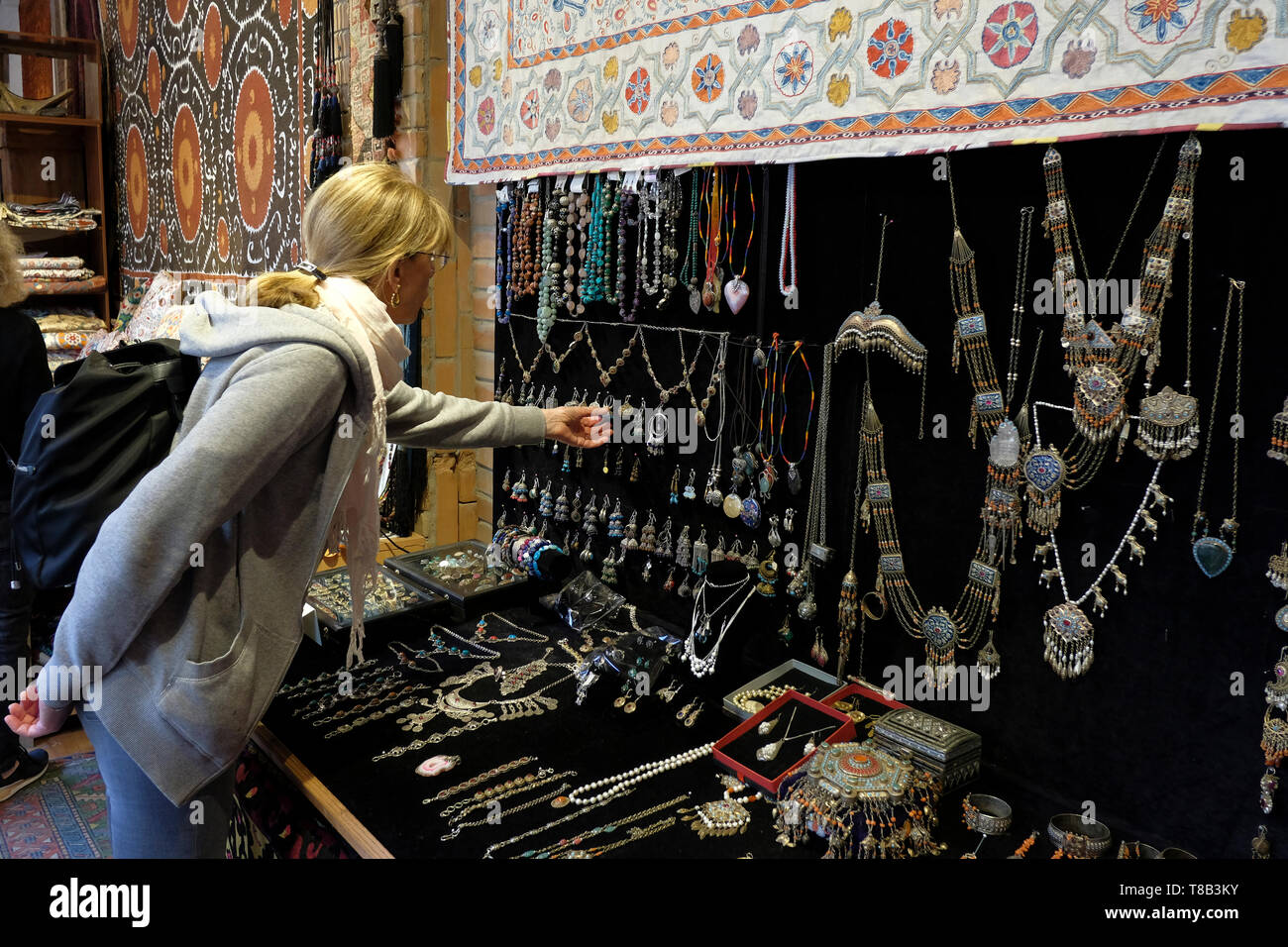 A tourist inspects traditional jewelry in a souvenir shop in Tashkent ...