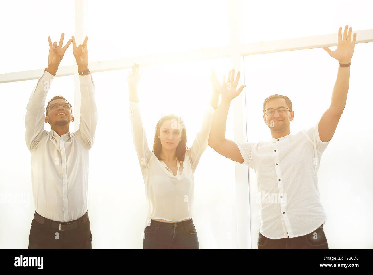 successful business team stands with hands up. photo with copy space ...