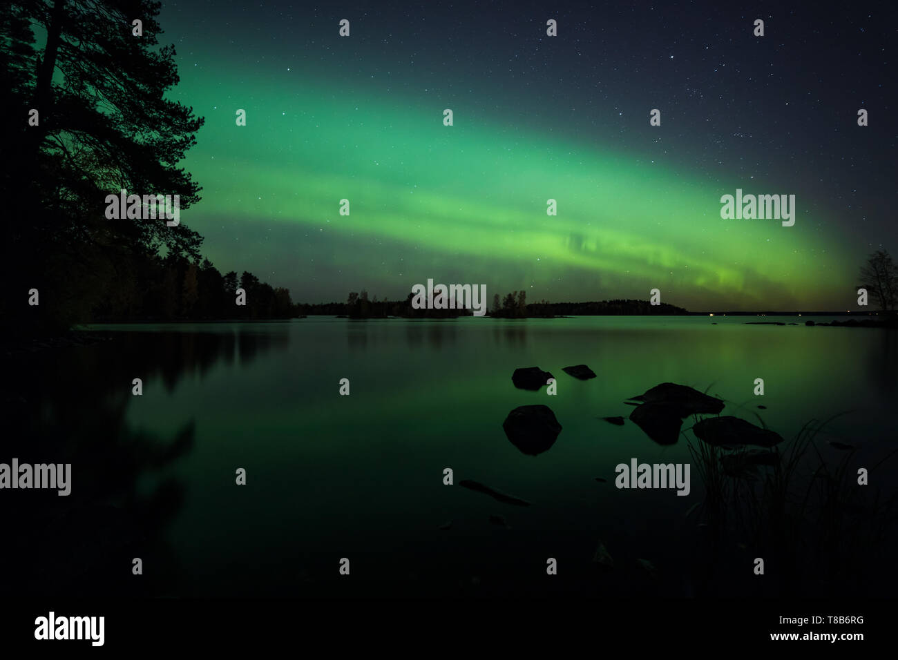 Beautiful northern lights over lake Stock Photo - Alamy