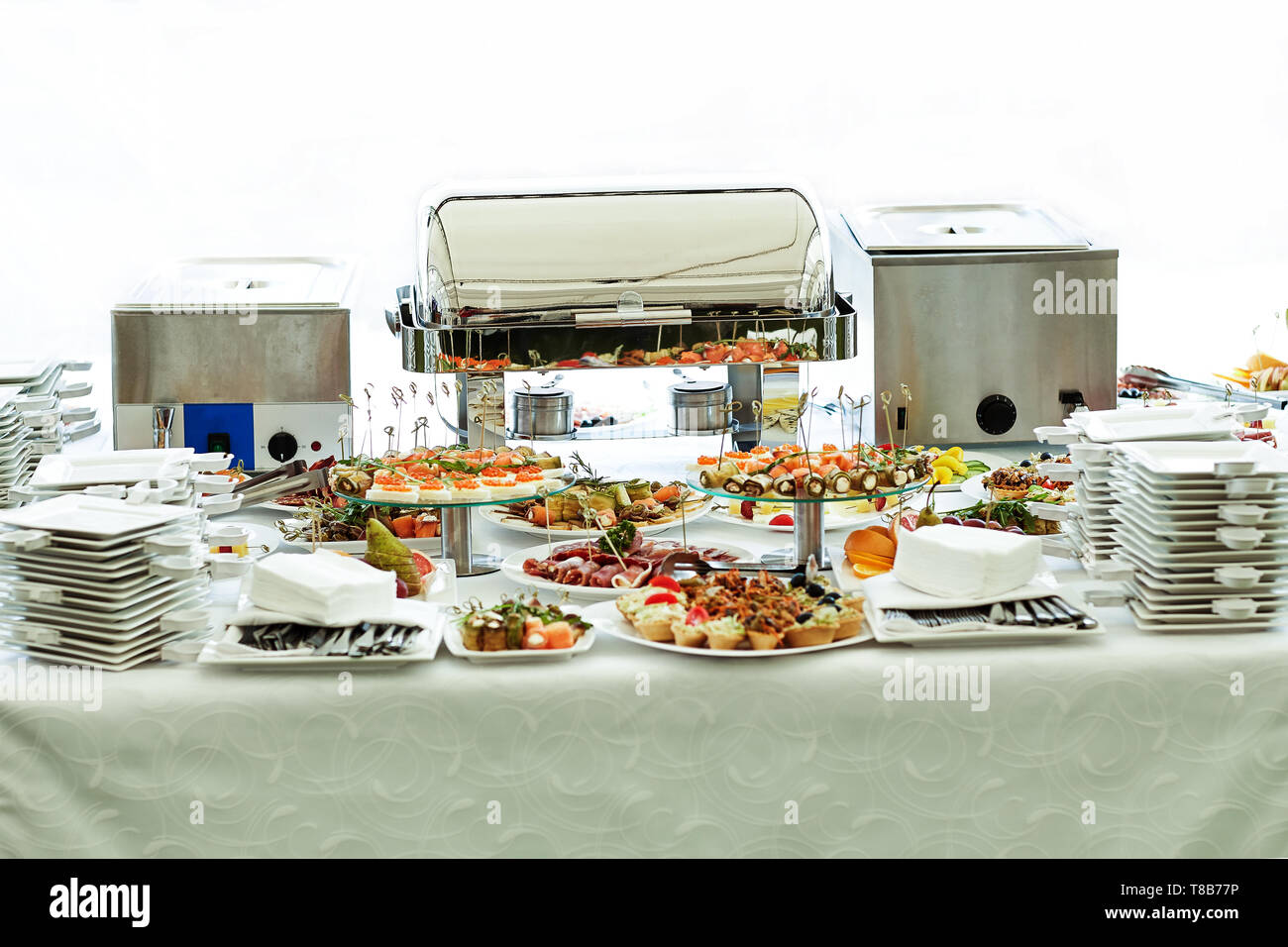 plates and a variety of dishes on the handout table in the restaurant ...