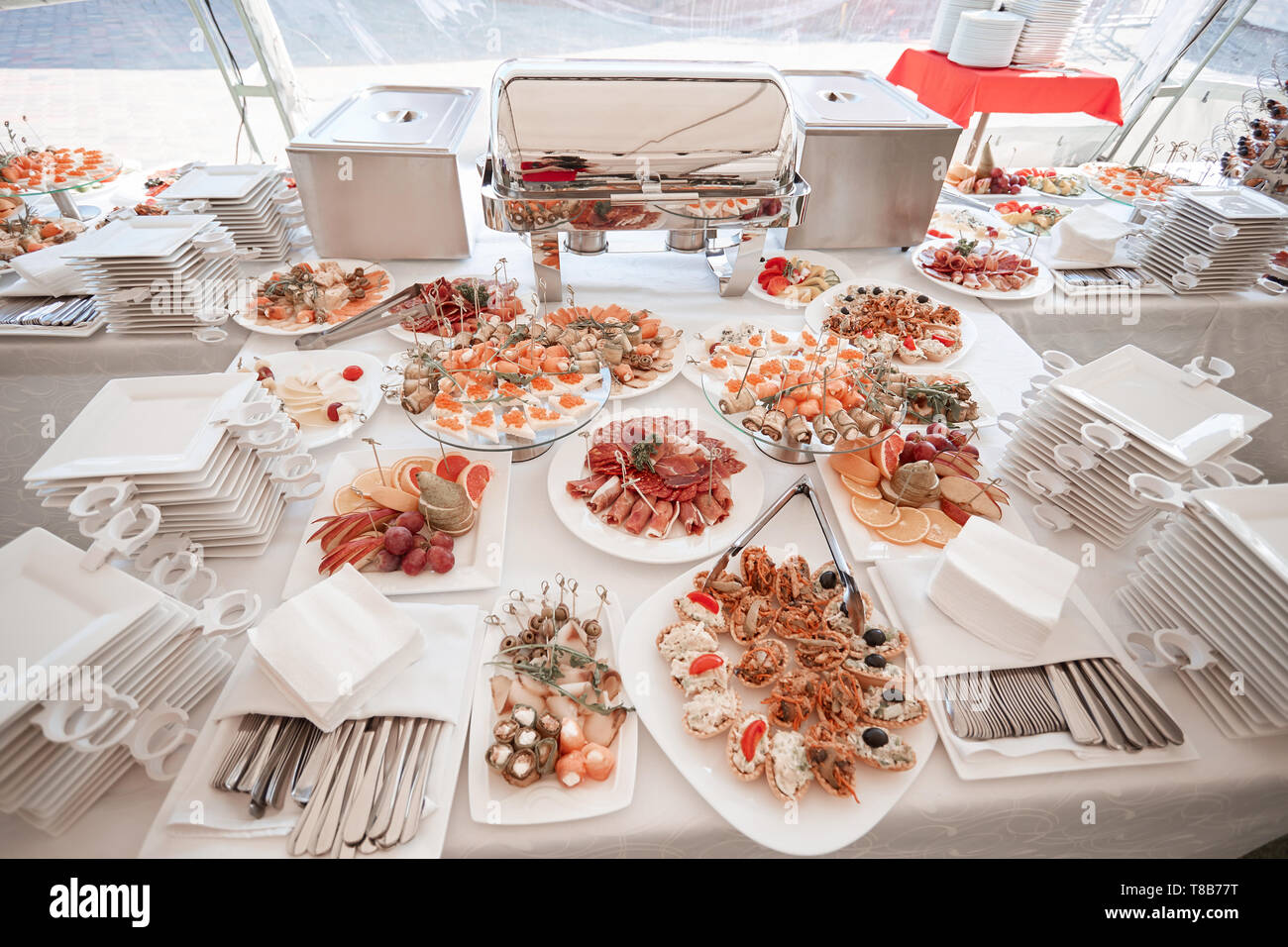 plates and a variety of dishes on the handout table in the restaurant ...