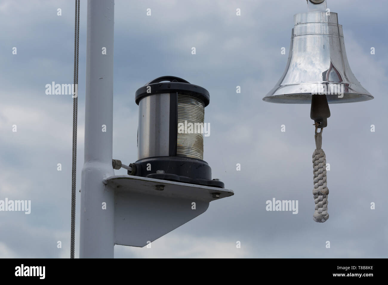 Maritime objects bell with rope and top light Stock Photo - Alamy