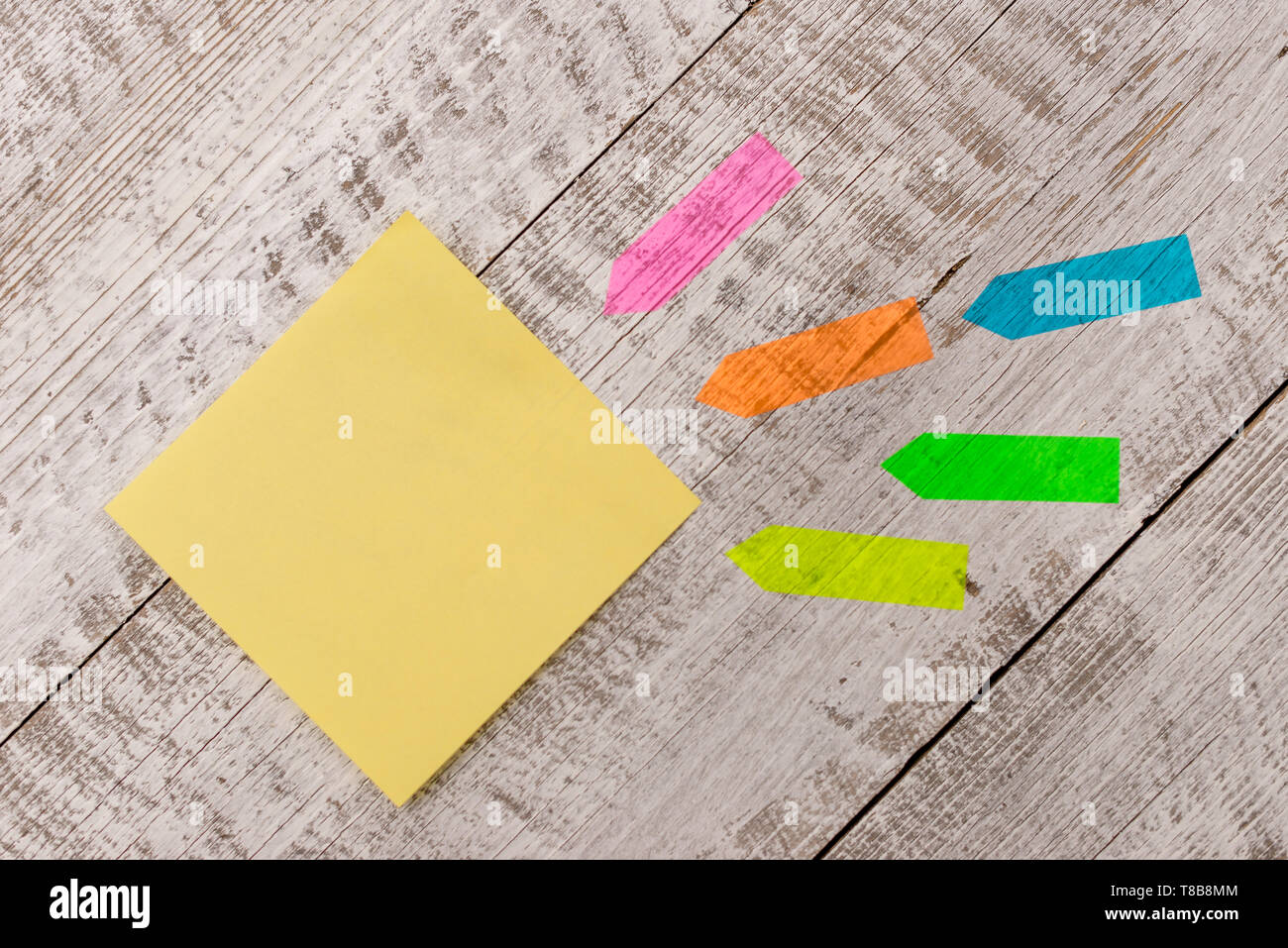 Plain note paper and line arrow stickers on the top of wooden table ...