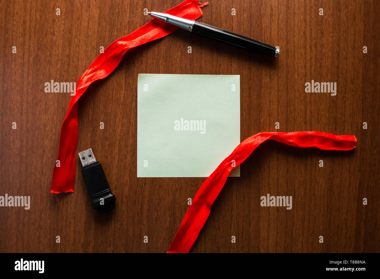 USB memory lying wooden table square blank note stripes ribbon up down ...