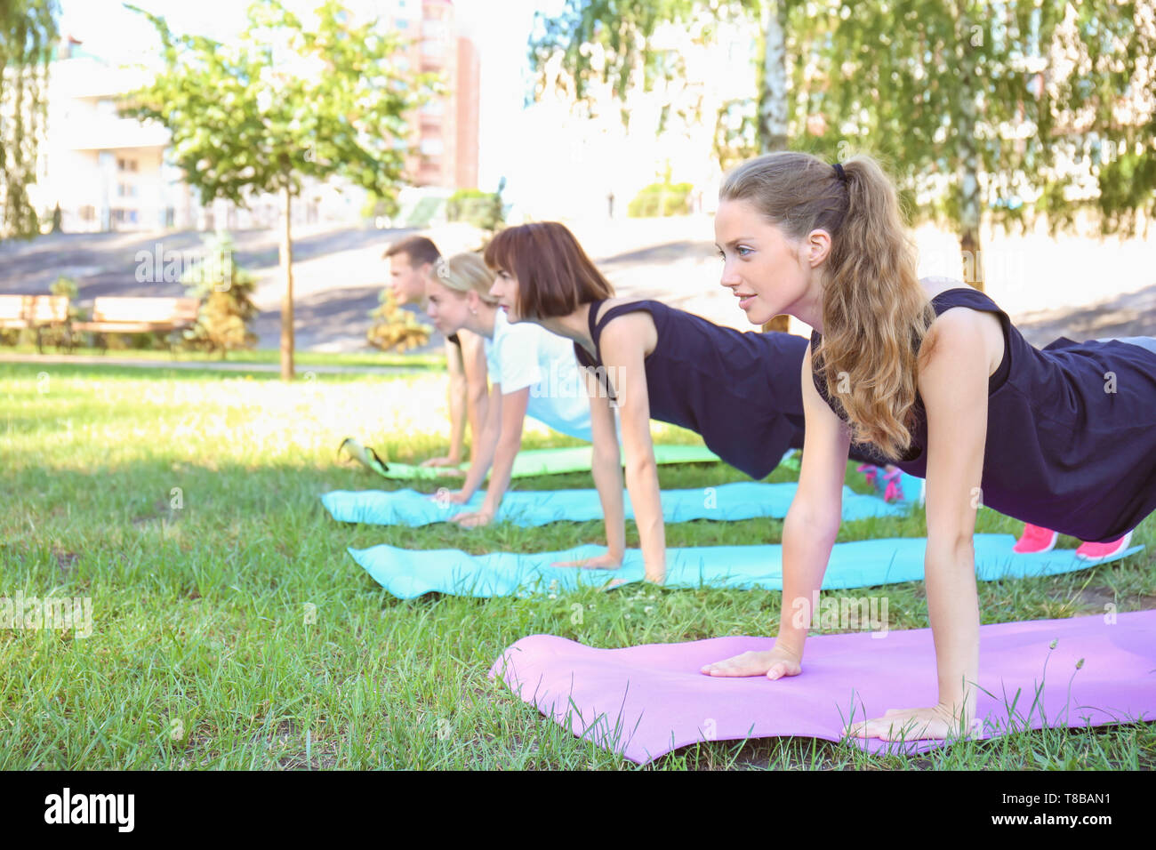 Group of young sporty people doing exercise outdoors Stock Photo - Alamy