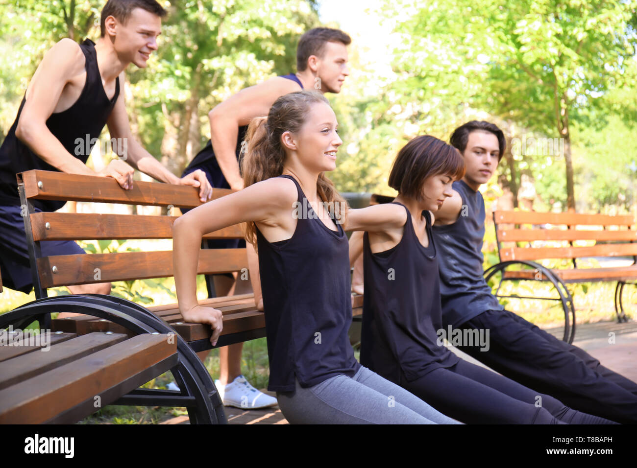 Group of young sporty people doing exercise outdoors Stock Photo - Alamy