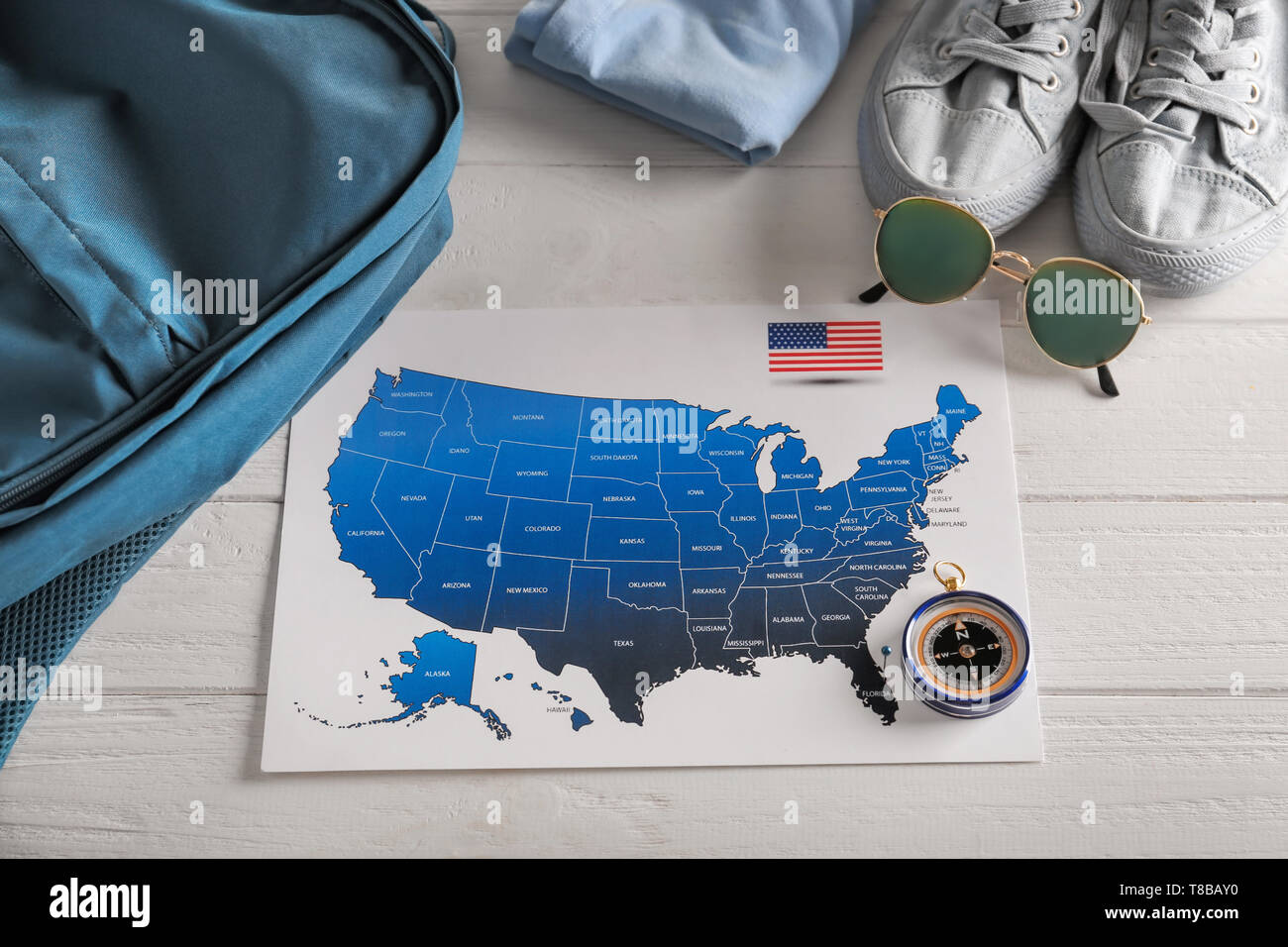 Composition with USA map, compass and clothes on wooden background ...